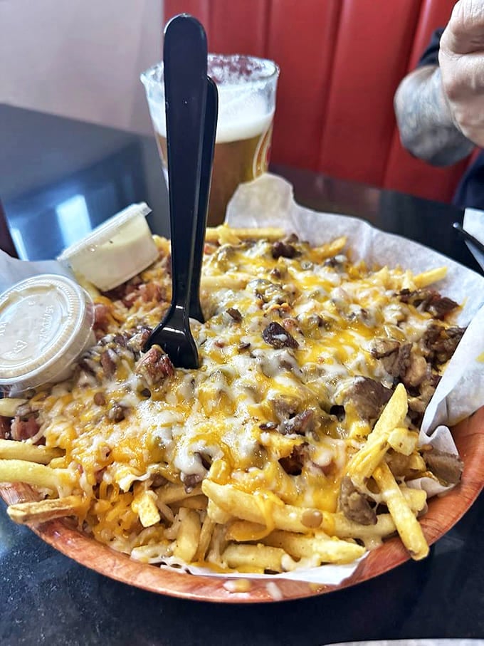 Fries transformed into a magnificent cheese-covered landscape that would make any cardiologist nervously reach for their prescription pad.