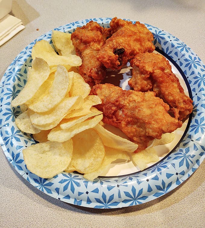 Golden-fried chicken drummies that crunch louder than your boots on gravel. Simple pleasures served on blue-patterned plates that grandma would approve of.