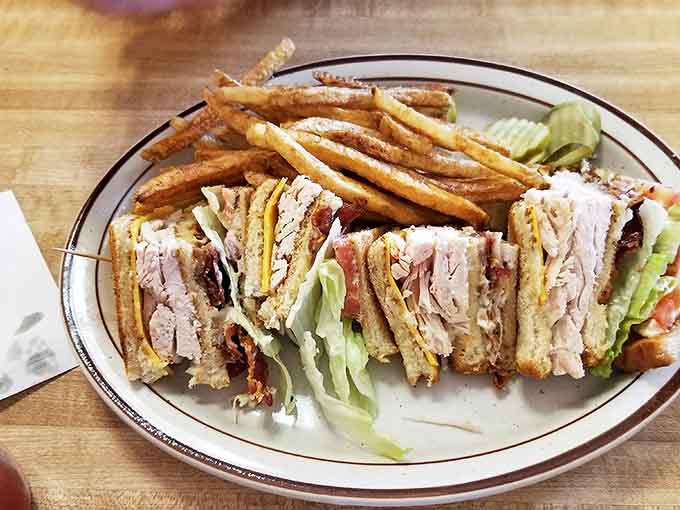 The club sandwich – architectural marvel of the diner world, where each perfectly toasted layer supports a delicious payload of turkey, bacon, and veggies.
