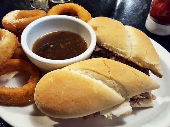 A French dip sandwich that demands to be dunked, paired with golden onion rings &ndash; proof that sometimes the best steakhouse order isn't steak at all.