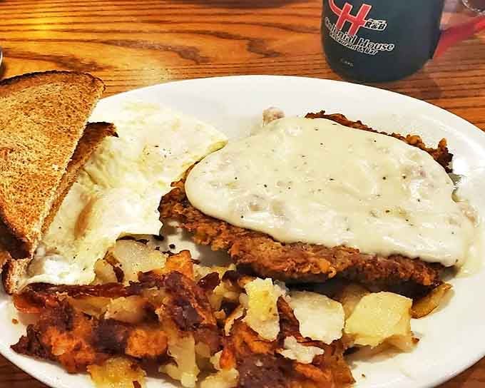 Behold the chicken fried steak breakfast&mdash;where country gravy cascades over crispy beef alongside eggs and potatoes in perfect morning harmony.