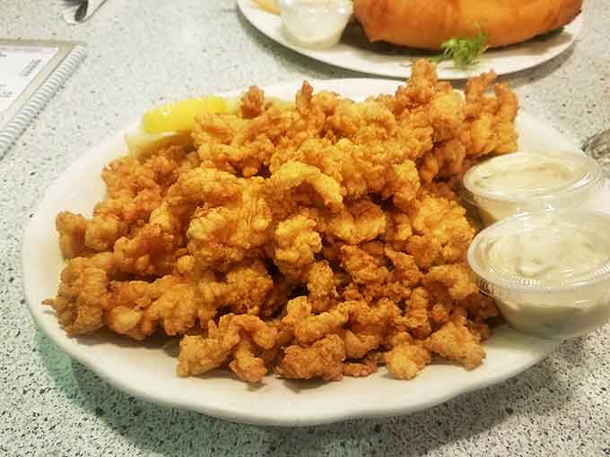 Fried clam strips piled high like golden treasure, waiting to be dipped in tartar sauce and devoured without a hint of restraint.