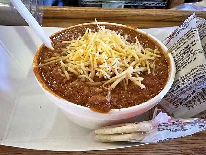 A bowl of homemade chili topped with cheese that doesn't need fancy garnishes to tell you it's been simmering to perfection.