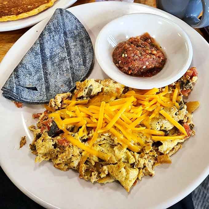Blue corn tortillas cradle a scramble that's having way too much fun. The cheese isn't melted&mdash;it's celebrating on top of this morning fiesta.