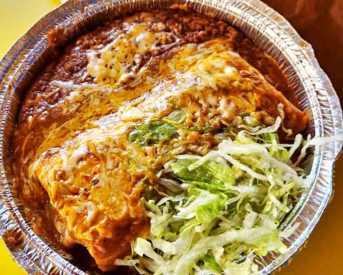 This enchilada isn't just covered in sauce—it's embraced by it. The melted cheese blanket on top is tucking it in for a flavor nap.