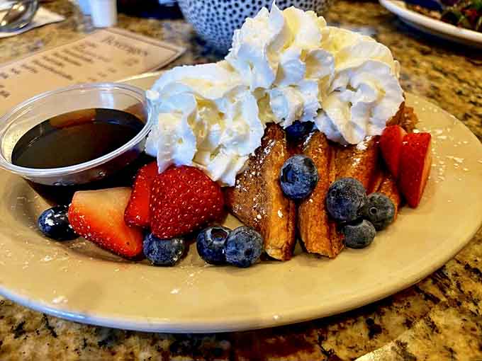 French toast that's dressed for success with fresh berries, whipped cream, and enough visual appeal to make your Instagram followers collectively drool on their phones.
