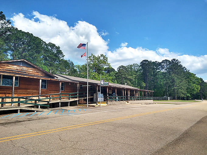 The visitor center stands like a rustic welcome mat, flying flags that say "adventure starts here" to all who arrive seeking natural treasures.