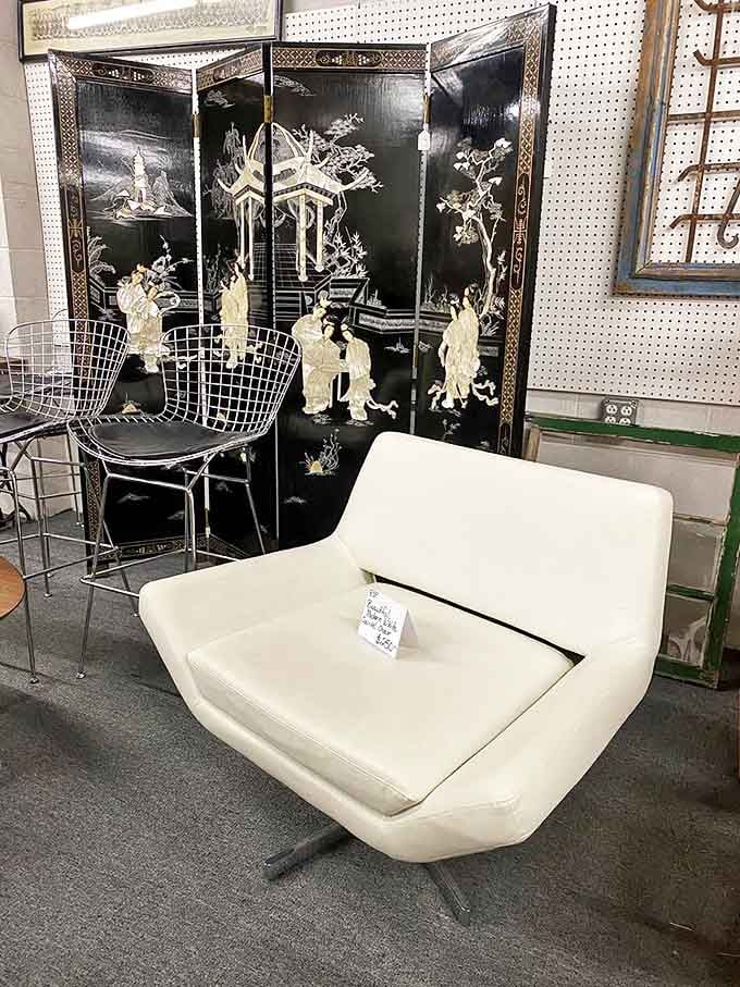 That cream-colored mid-century chair has seen things. Behind it, an Asian-inspired screen whispers tales of design trends from another era.