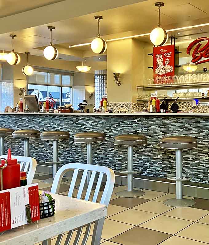 Counter seating at Bernie's offers front-row tickets to the culinary show, with the vintage "Bake Case" sign nodding to diners past.