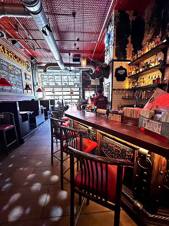 The dining area balances industrial chic with barbecue joint authenticity. That red ceiling draws your eye up, but the food pulls it right back down.