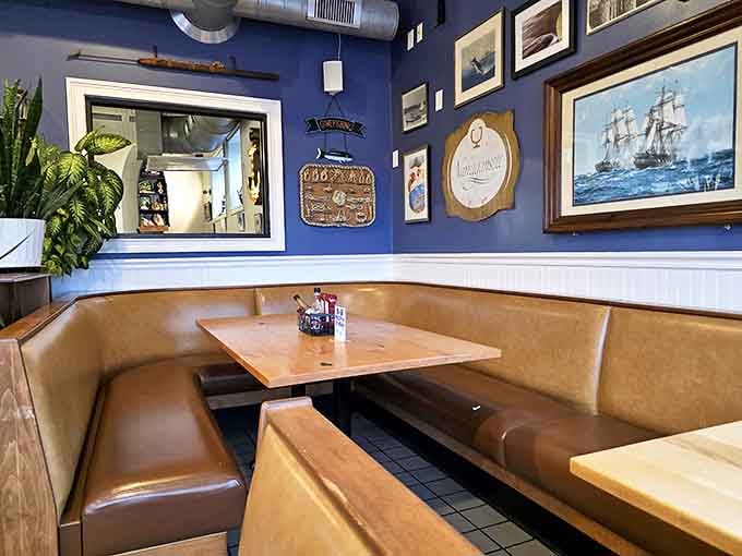 Navy blue walls adorned with maritime history &ndash; dining room decor that says "the ocean and I go way back."