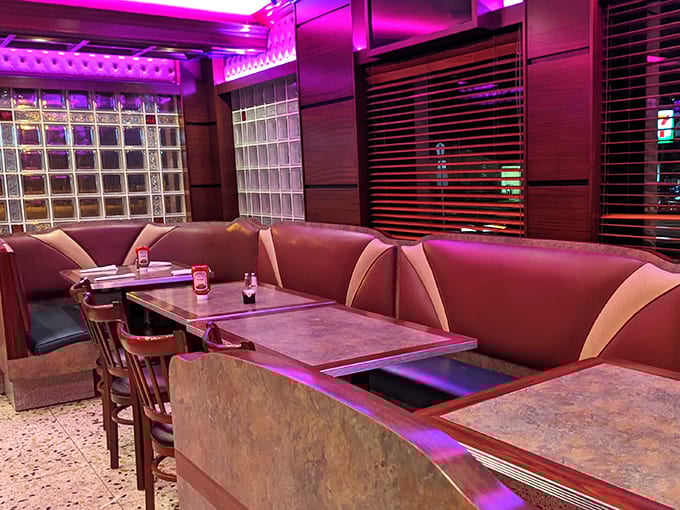 Pink neon bathes these booths in a glow that makes everyone look like they're starring in their own late-night film noir about pancakes and life decisions.