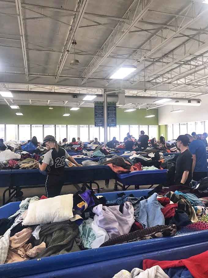 Shoppers strategically positioned around bins, maintaining the delicate ecosystem of thrift etiquette while eyeing potential treasures.