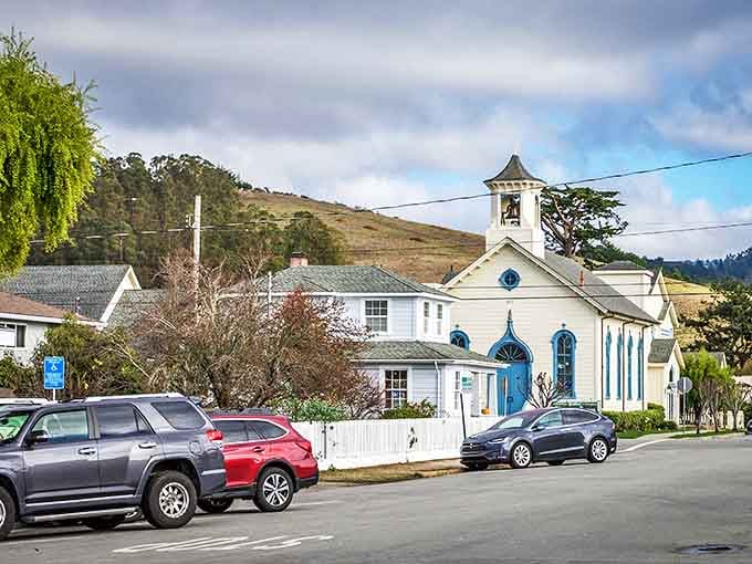 Half Moon Bay's charming blue-doored chapel stands like a beacon of tranquility, surrounded by coastal hills that seem to hug the little town.