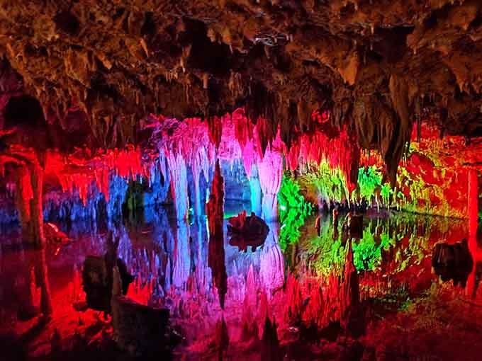 The cave's colorful glow and crystal-clear reflections create an almost surreal, otherworldly atmosphere.