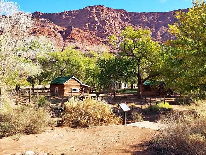 Log cabins nestled under towering cliffs where cottonwoods provide shade and pioneers once found their slice of paradise.