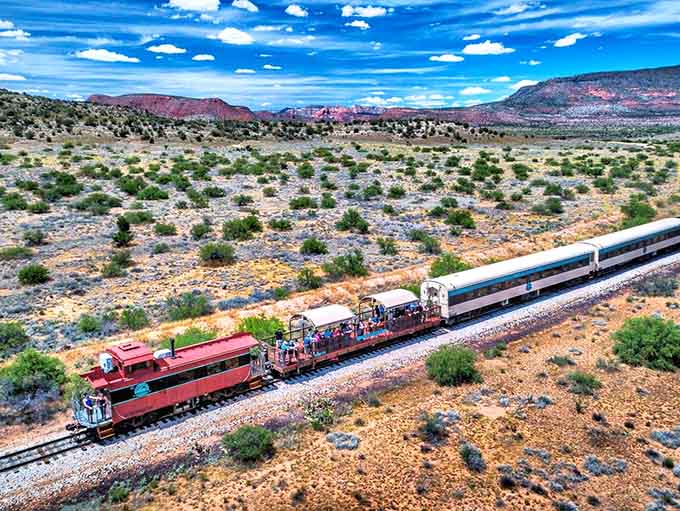 Red rocks, blue skies, and a train winding through wilderness only accessible by these very tracks.