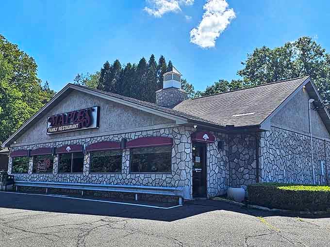 The stone facade of Maples Family Restaurant stands as Middlebury's beacon of breakfast bliss, its iconic red sign promising comfort food paradise within.