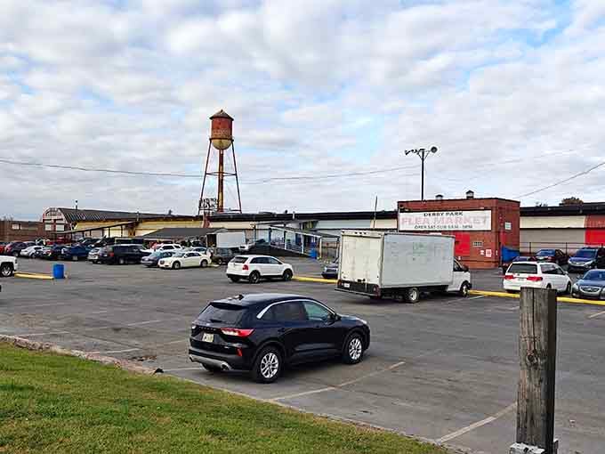 The bustling parking lot outside Derby Park Flea Market, with its iconic water tower standing sentinel over treasure hunters' vehicles.