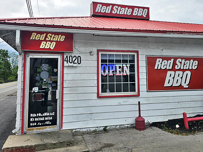 The unassuming exterior of Red State BBQ, where bold red signage promises authentic barbecue treasures within this modest Lexington establishment.