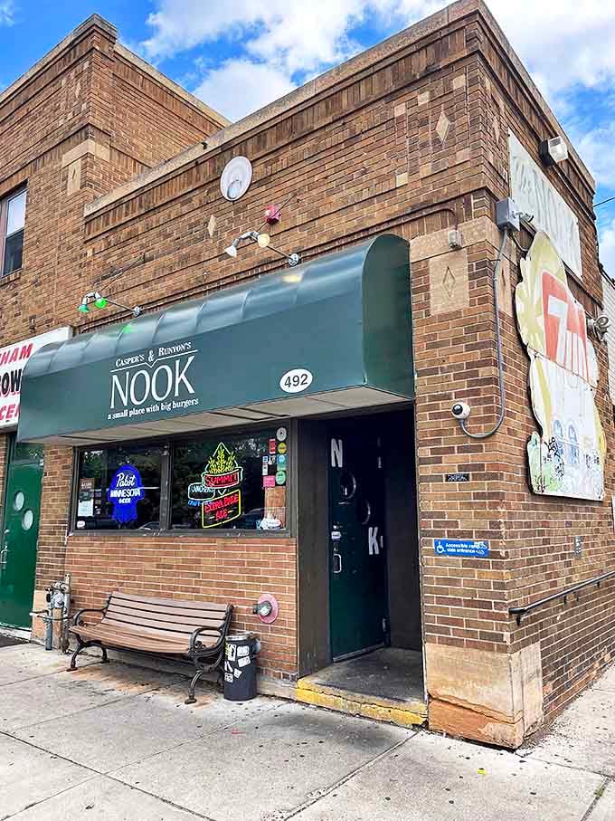 The unassuming brick exterior of The Nook proves once again that the best burgers often hide behind the most modest facades. That green bench has witnessed countless waiting patrons dreaming of cheese-stuffed perfection.