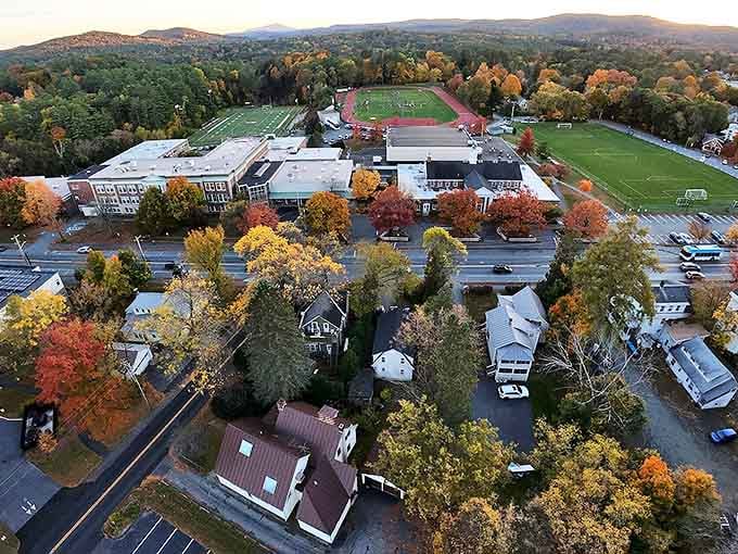 Aerial view of Hanover during peak fall foliage, showcasing the stunning autumn colors surrounding Dartmouth's campus and athletic fields.