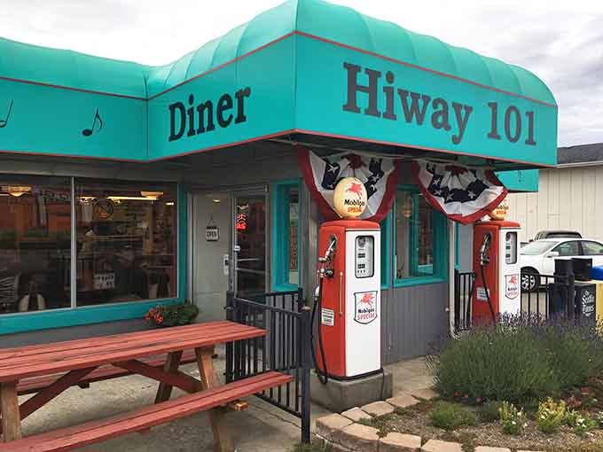 The iconic turquoise exterior of Hi-Way 101 Diner, complete with vintage gas pumps and patriotic bunting&mdash;a true roadside time capsule.