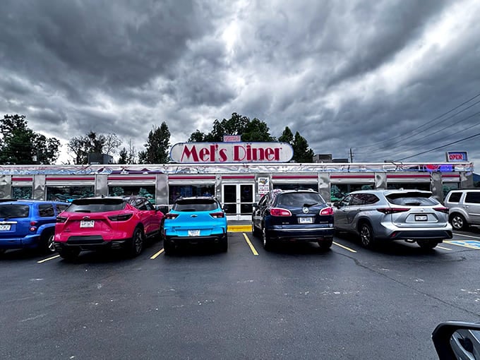 The gleaming silver exterior of Mel's Classic Diner stands defiant against moody Smoky Mountain skies, a chrome time capsule beckoning hungry travelers with its neon promise.