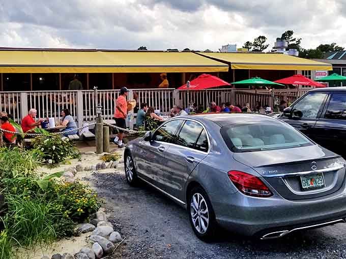 Colorful umbrellas dot the bustling outdoor deck where happy diners gather for fresh seafood under Bethany Beach's beautiful sky.