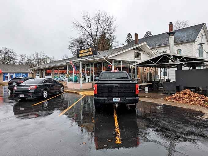 The unassuming exterior of Goodstuff Smokehouse on a rainy day, where BBQ magic happens behind this modest New England facade.