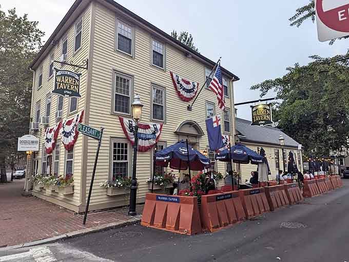 The yellow clapboard exterior of Warren Tavern stands as a colonial time capsule, complete with patriotic bunting and a welcoming patio for history buffs and foodies alike.
