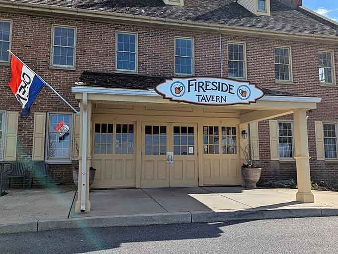 The welcoming entrance of Fireside Tavern showcases its historic brick fa&ccedil;ade, inviting yellow doors, and charming covered porch.