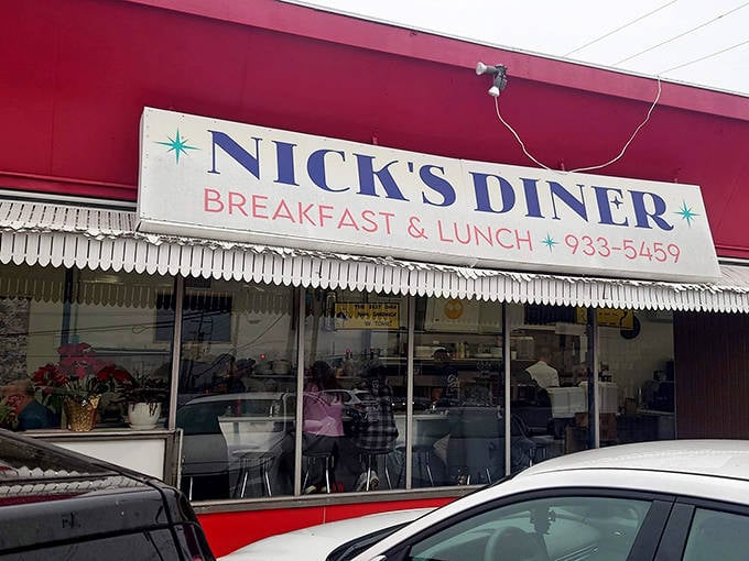 The iconic white awning of Nick's Diner beckons like a lighthouse for the breakfast-starved, promising morning salvation in classic diner form.