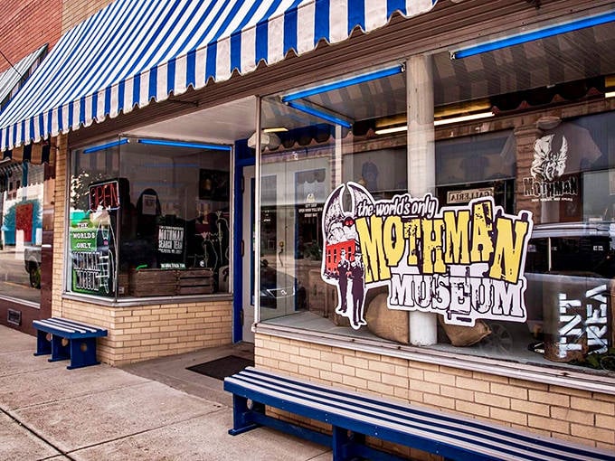 The unassuming storefront of the world's only Mothman Museum beckons curious visitors with its blue-striped awning and promise of cryptid wonders within.