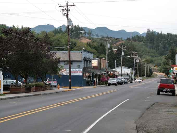 Mountains frame the main street like nature's own welcome committee, standing guard over this peaceful coastal sanctuary.