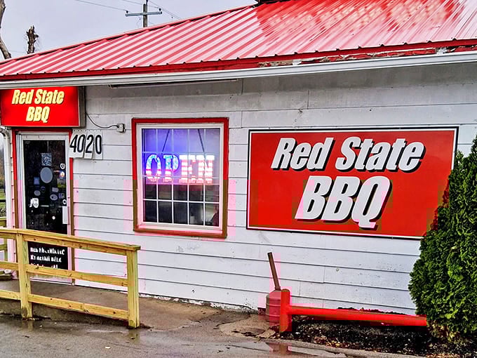 The distinctive red-trimmed facade of Red State BBQ at 4020 Georgetown Road&mdash;proof that extraordinary barbecue often hides in the most unpretentious places.