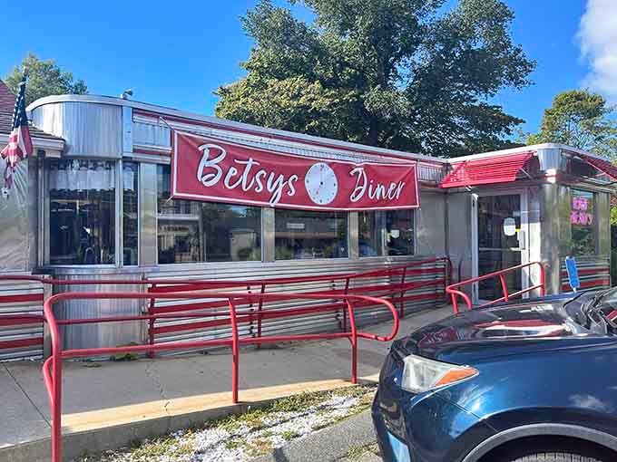 The entrance beckons with red railings and American flags, promising comfort food and the kind of service that remembers your name.