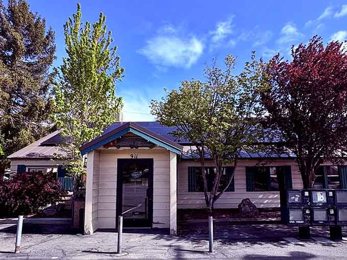 The Cottage Cafe's cheerful yellow exterior with teal trim stands like a beacon of breakfast hope against Cle Elum's brilliant blue sky.