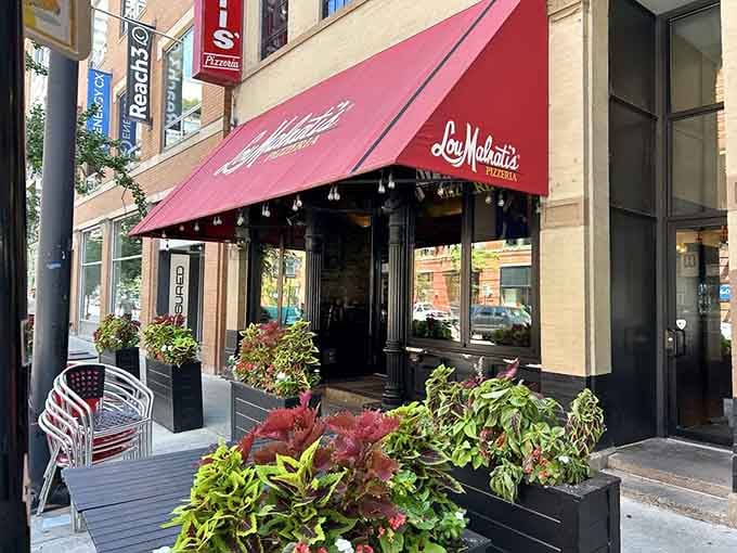 That red awning beckons like a lighthouse guiding hungry ships to shore, promising deep dish salvation within.