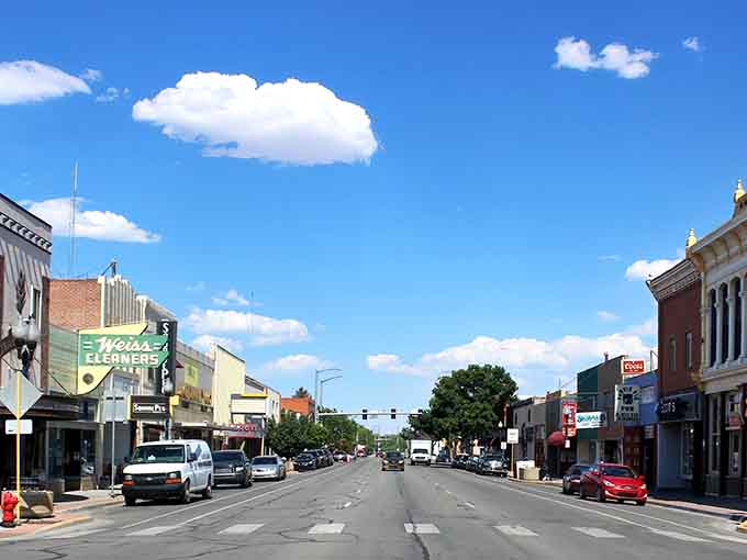 Main Street stretches wide under that impossibly blue Colorado sky, looking like America before everything got ridiculously expensive.