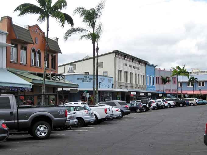 The iconic Hilo Bay Building anchors the corner with its distinctive architecture and those impossibly orange palm trees.