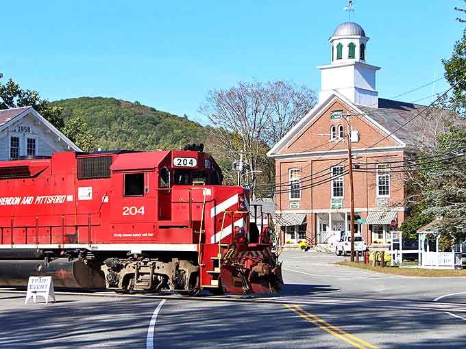 The iconic red Vermont Railway locomotive rolls through Chester's historic center, where time seems to move at its own delightful pace.