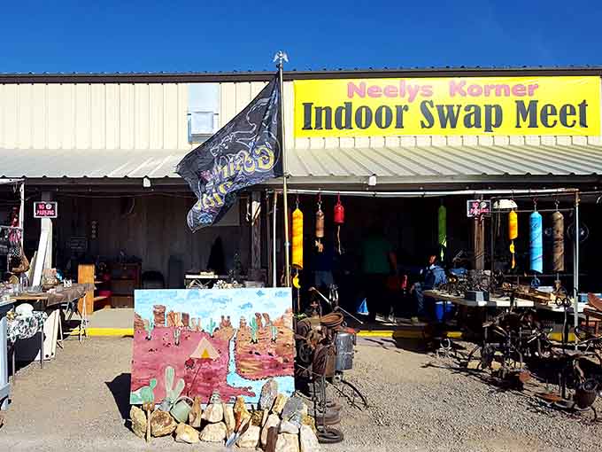 The desert sun gleams off Neely's Korner's iconic yellow sign, where treasure hunters gather beneath colorful wind chimes and handcrafted desert art.