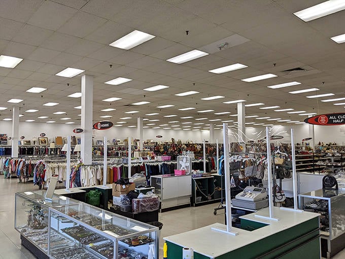 Fluorescent lights illuminate an endless sea of possibility, where clothing racks stand like sentinels guarding vintage fashion treasures from decades past.