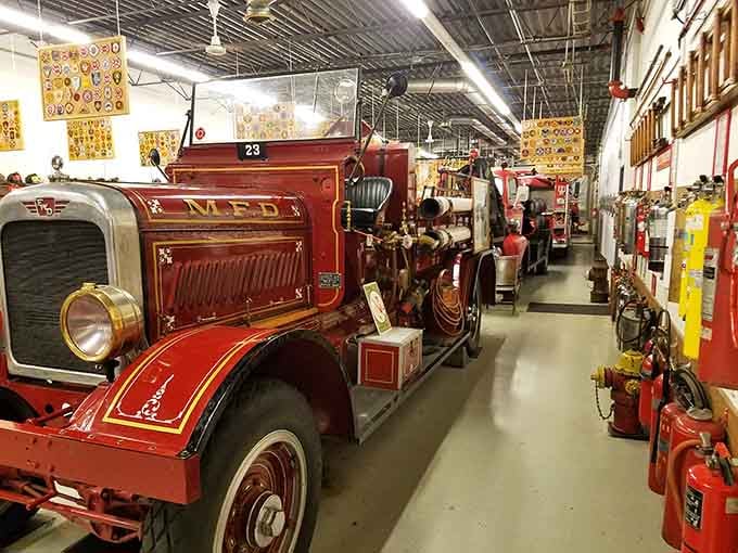 Beautifully restored antique fire engines line the museum floor, with colorful department patches covering the walls like firefighting wallpaper.