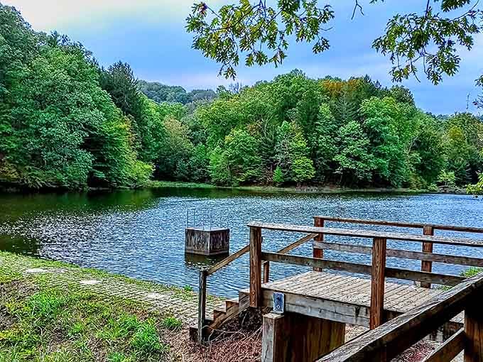 A wooden dock invites contemplation at one of Brown County's serene lakes, where the water mirrors the surrounding forest like nature's own infinity pool.