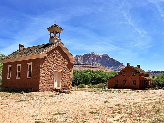 The schoolhouse and Russell Home create a perfect historical tableau, with mountains standing guard like eternal sentinels.