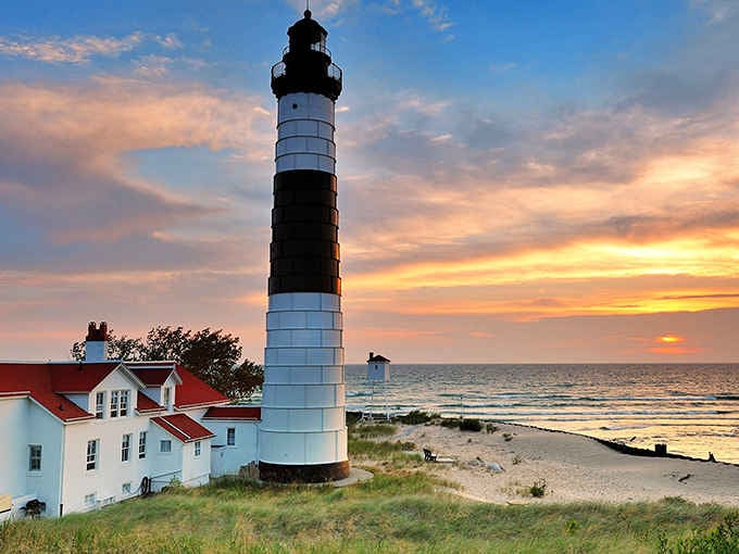 That iconic black-and-white striped lighthouse standing guard over Lake Michigan like a candy cane with a serious job.