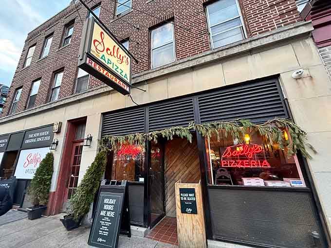 That neon glow and brick facade have been calling pizza pilgrims to Wooster Street for generations.