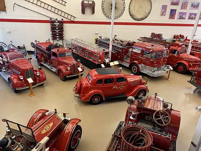 A sea of gleaming red fire trucks stretches across the museum floor like a vintage dream come true.